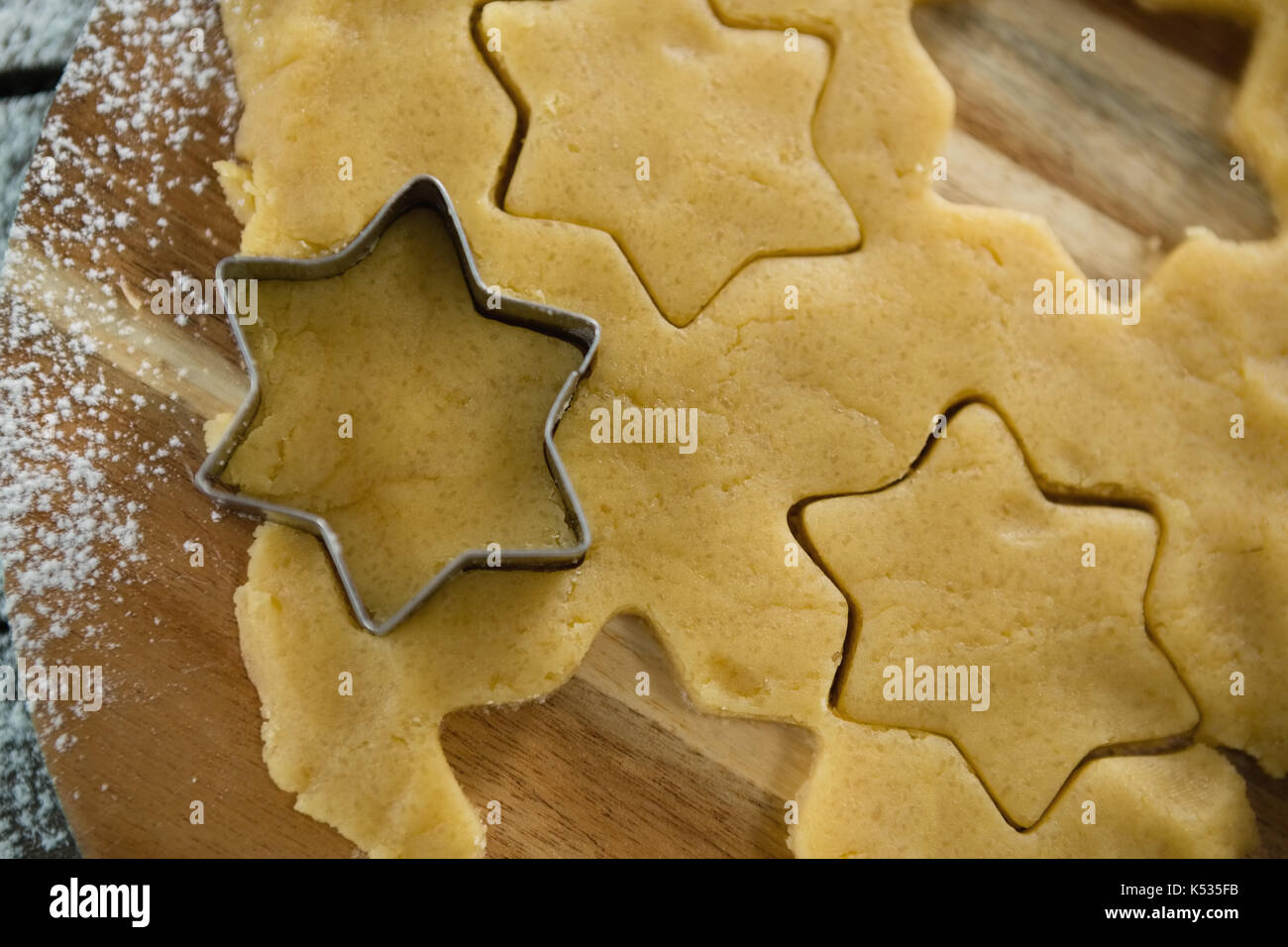Overhead view of star shape cutter on dough over cutting board Stock ...