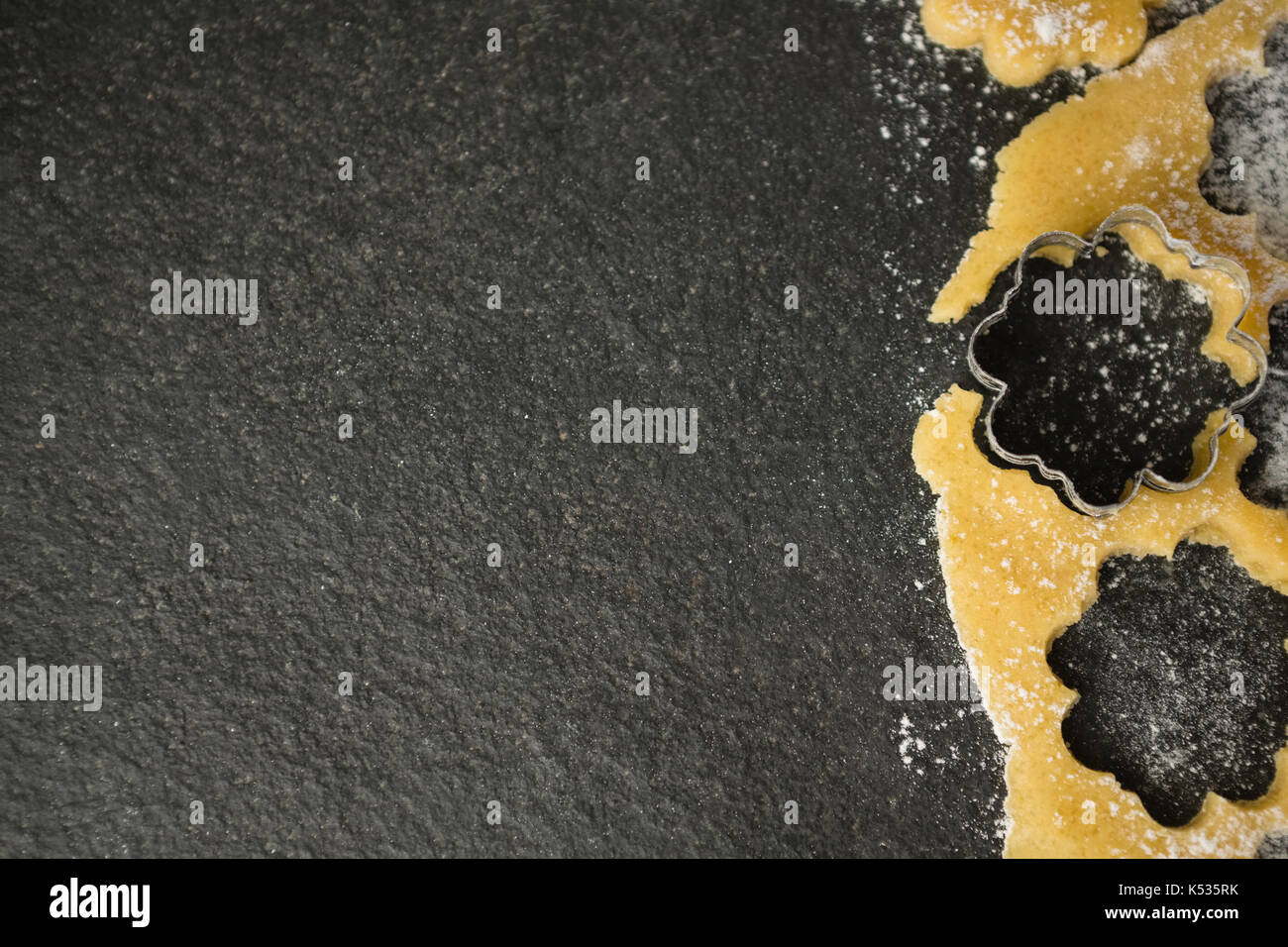 Flower shape pastry cutter on dough at table Stock Photo - Alamy