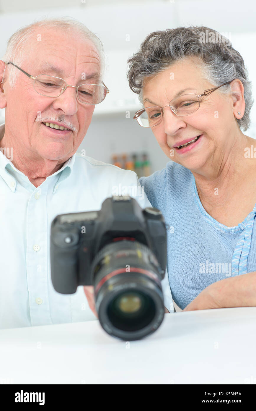old couple looking on camera screen with pictures Stock Photo - Alamy