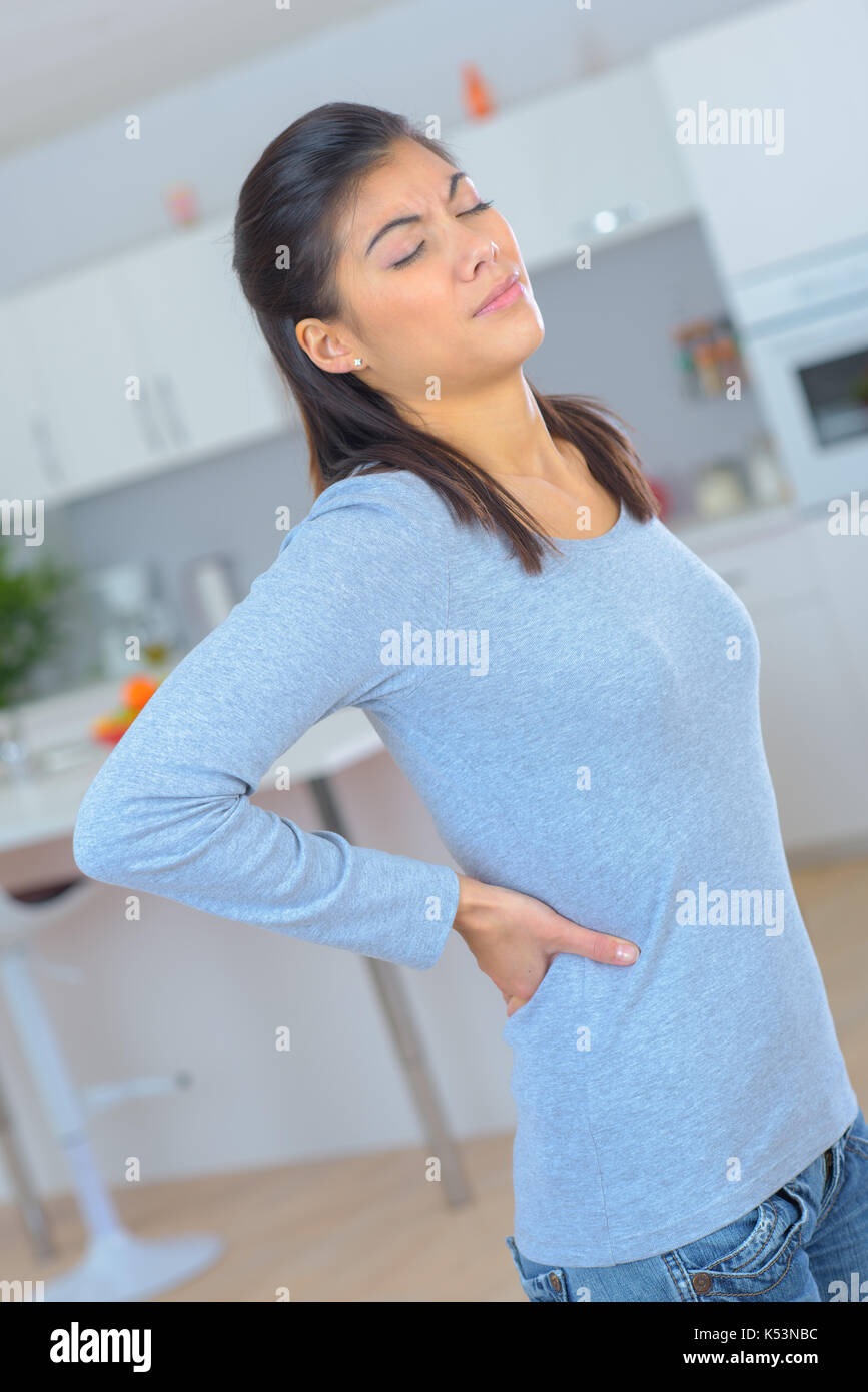 young woman suffering from back ache at home Stock Photo - Alamy