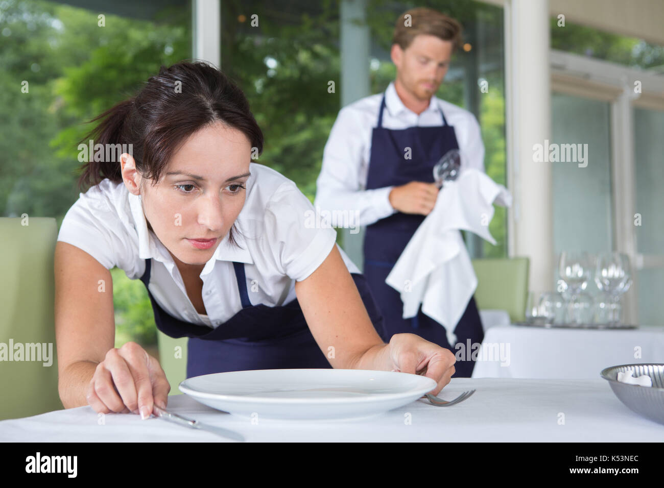 waitress setting the table in a restaurant Stock Photo - Alamy