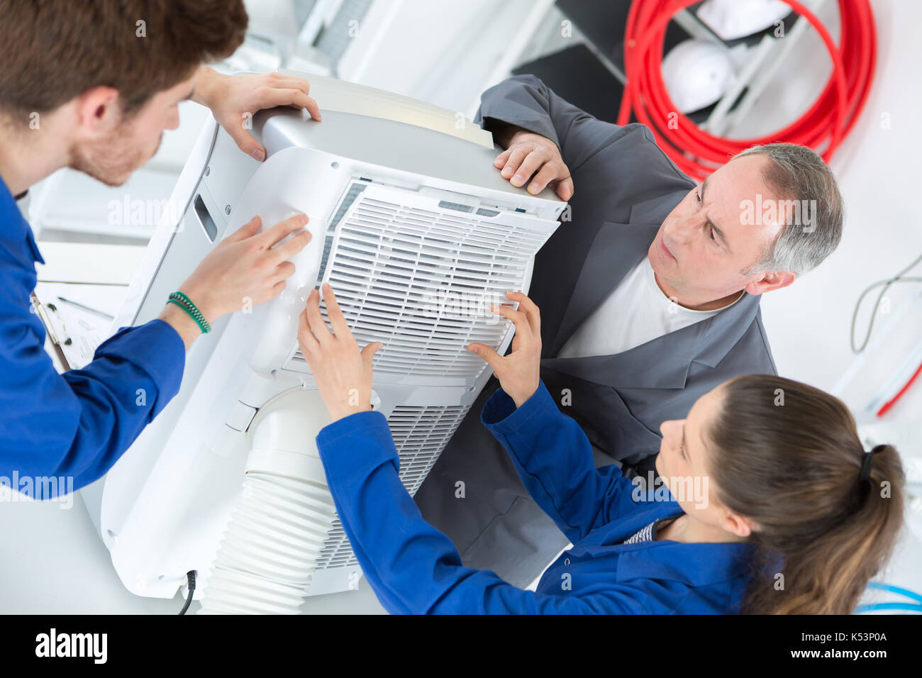 Young people woking on air conditioning unit Stock Photo - Alamy