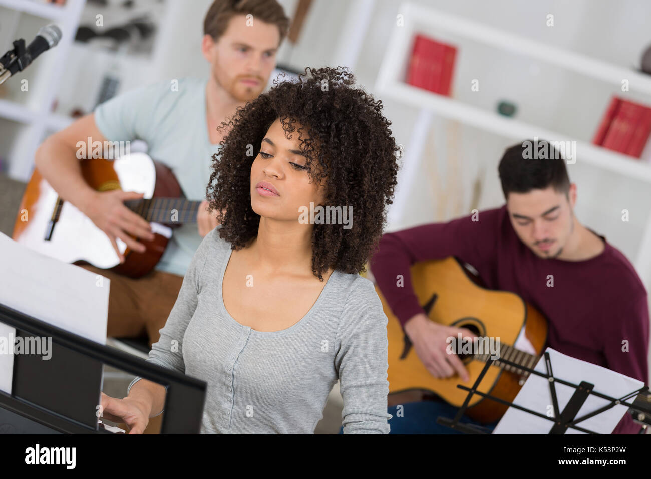 young band music playing a song in a recording studio Stock Photo - Alamy