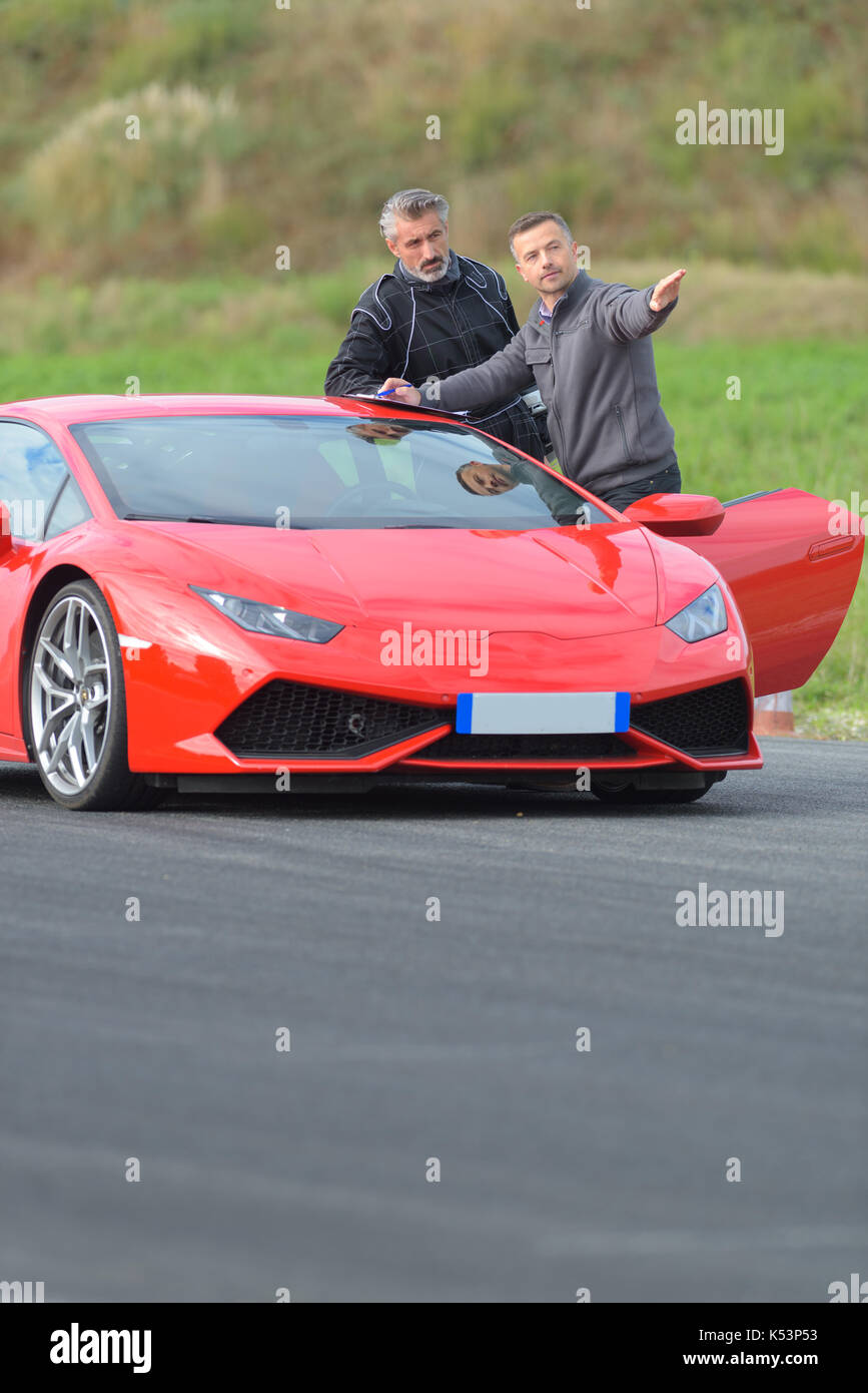 2 men standing nect to lamborghini race car on track Stock Photo - Alamy
