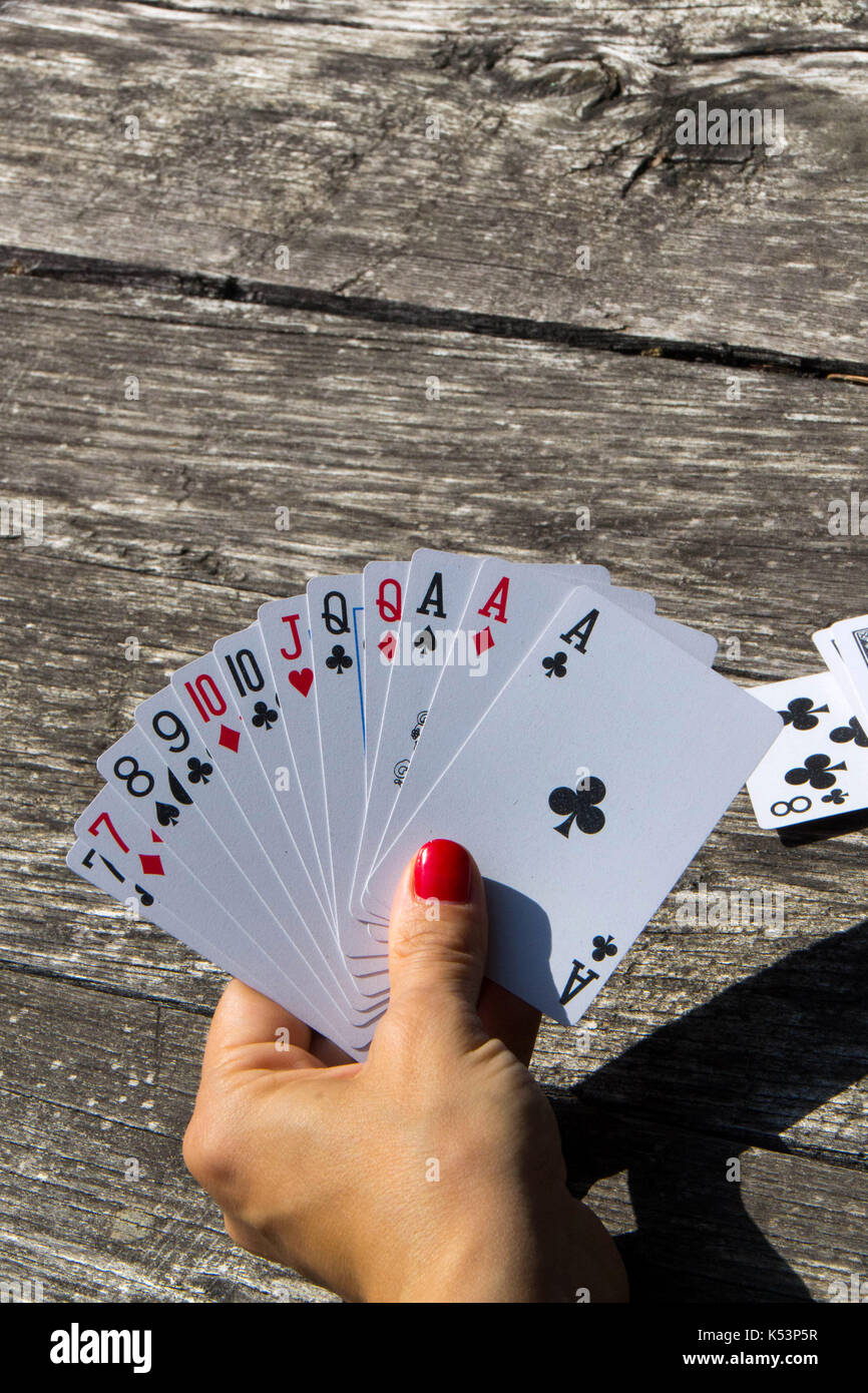 The lady plays cards. Women hand holding cards for play Stock Photo - Alamy