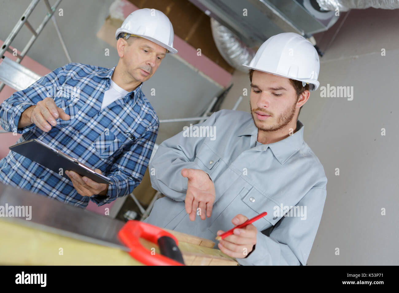 engineer and apprentice working in factory Stock Photo - Alamy