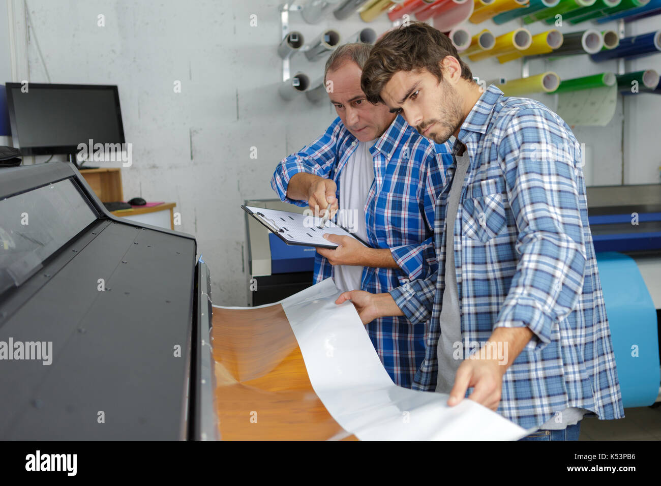 man and apprentice watching printing machine Stock Photo - Alamy