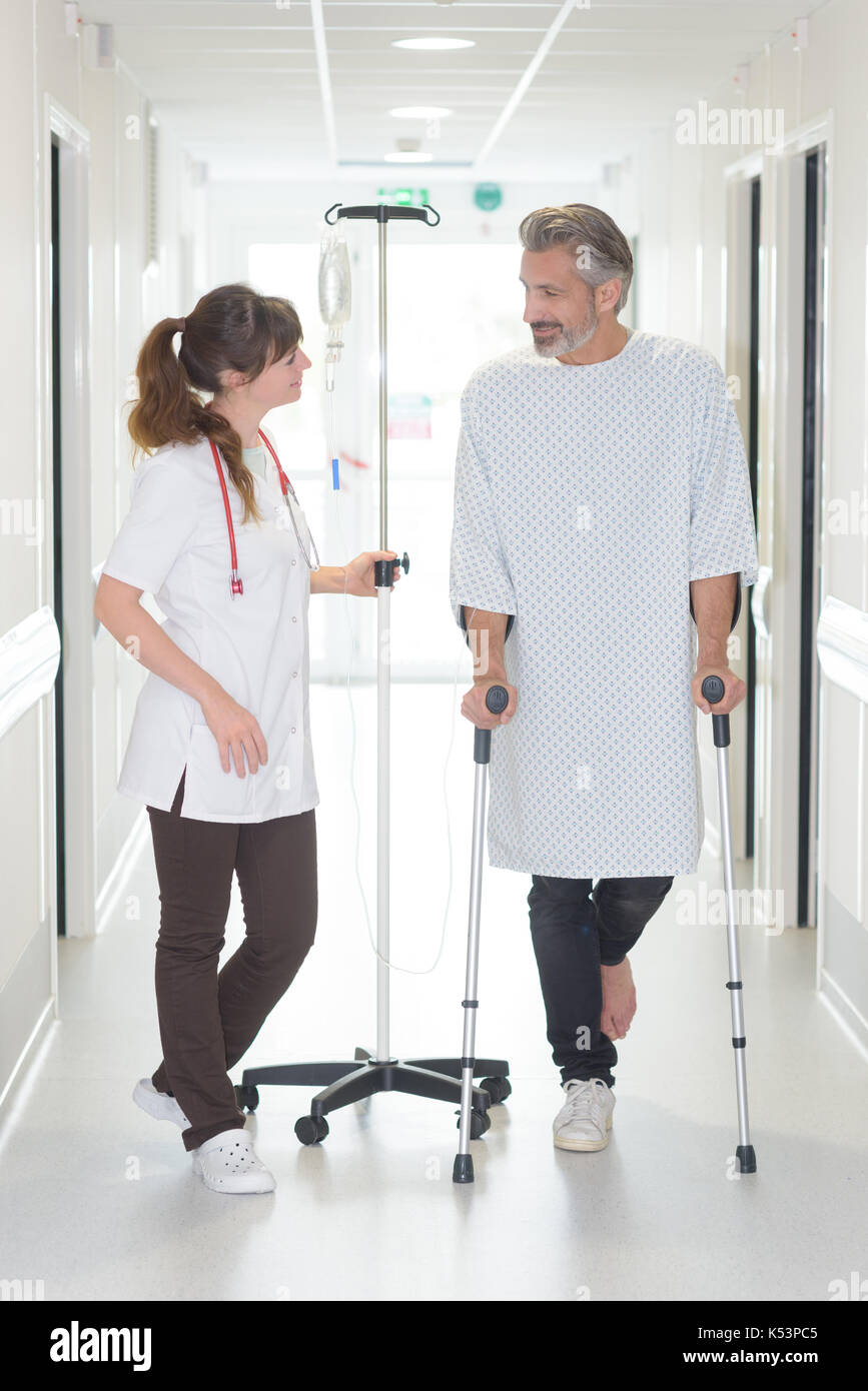 patient using cane while looking at female doctor Stock Photo - Alamy