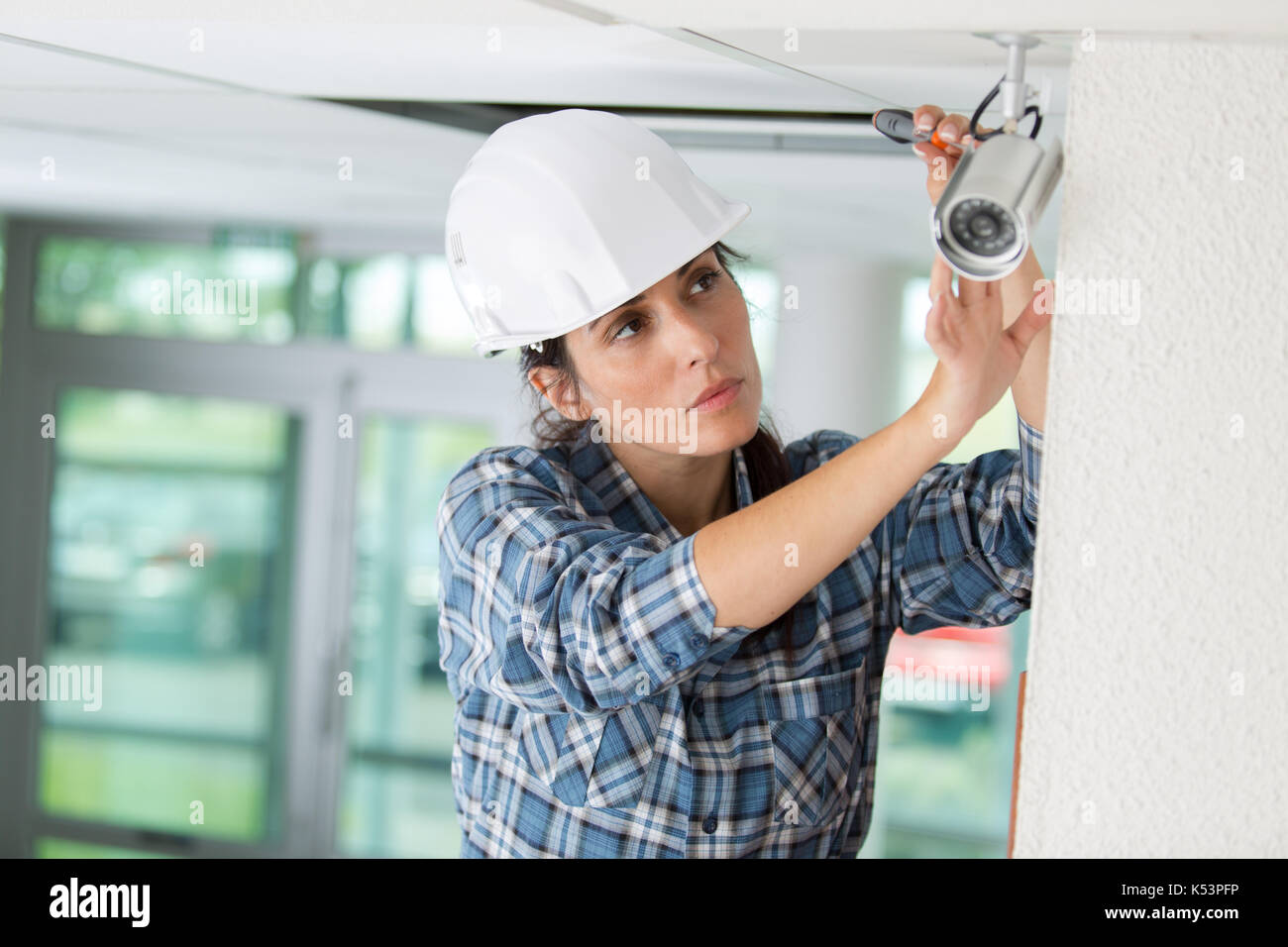 pretty female cctv installing security camera Stock Photo - Alamy