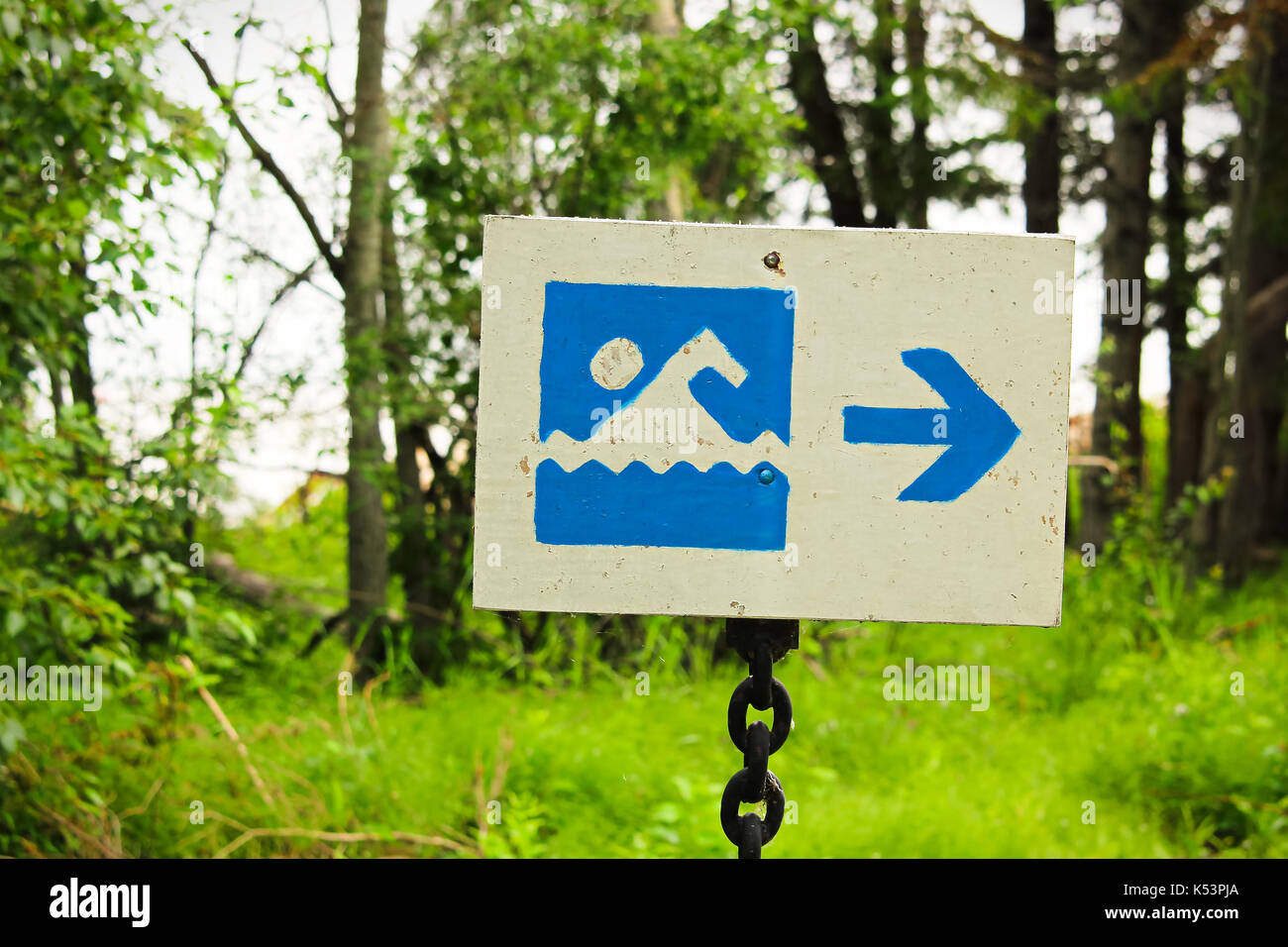 A blue beach beach sign with a direction arrow Stock Photo - Alamy