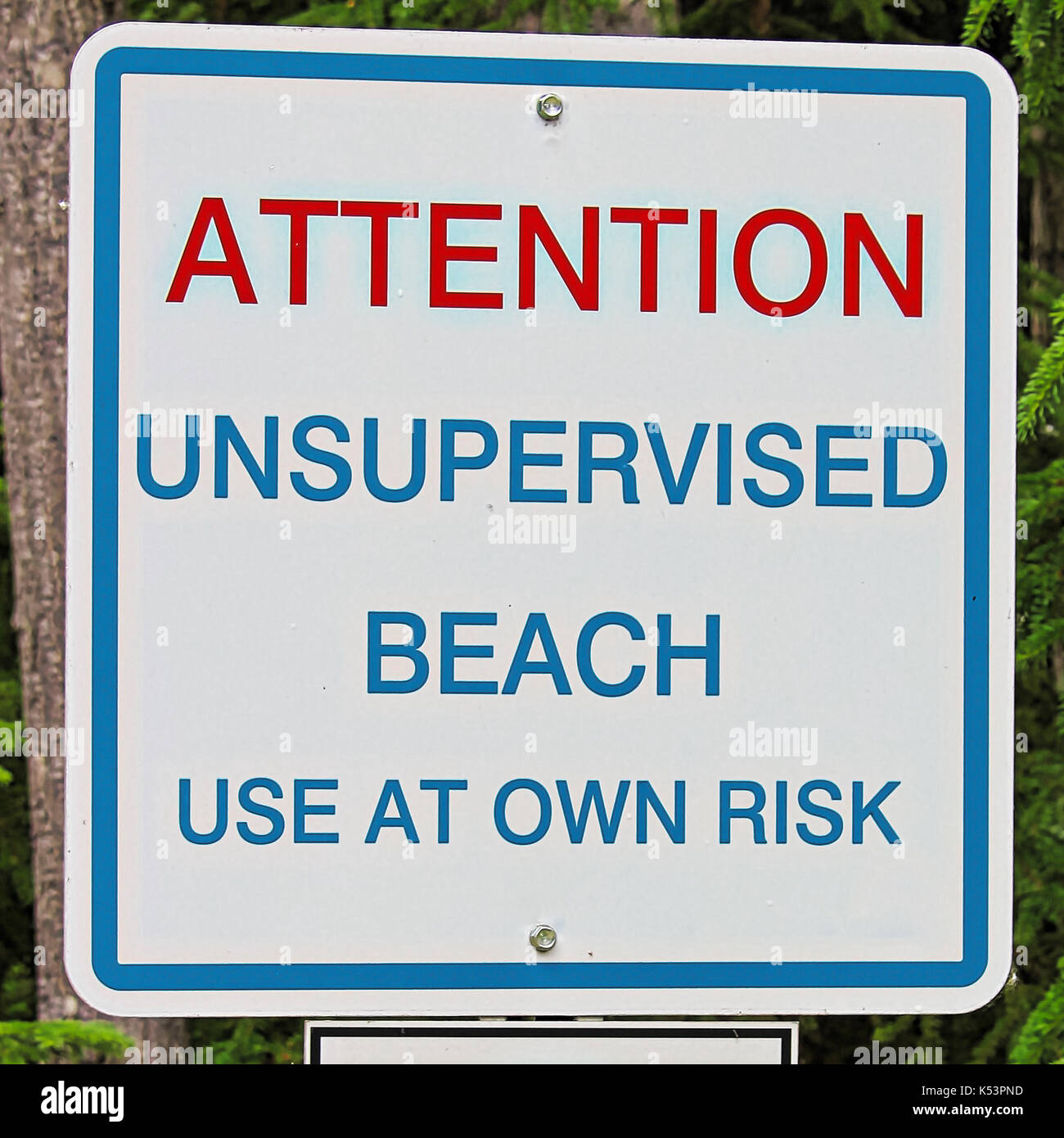 An attention unsupervised beach use at own risk sign Stock Photo - Alamy