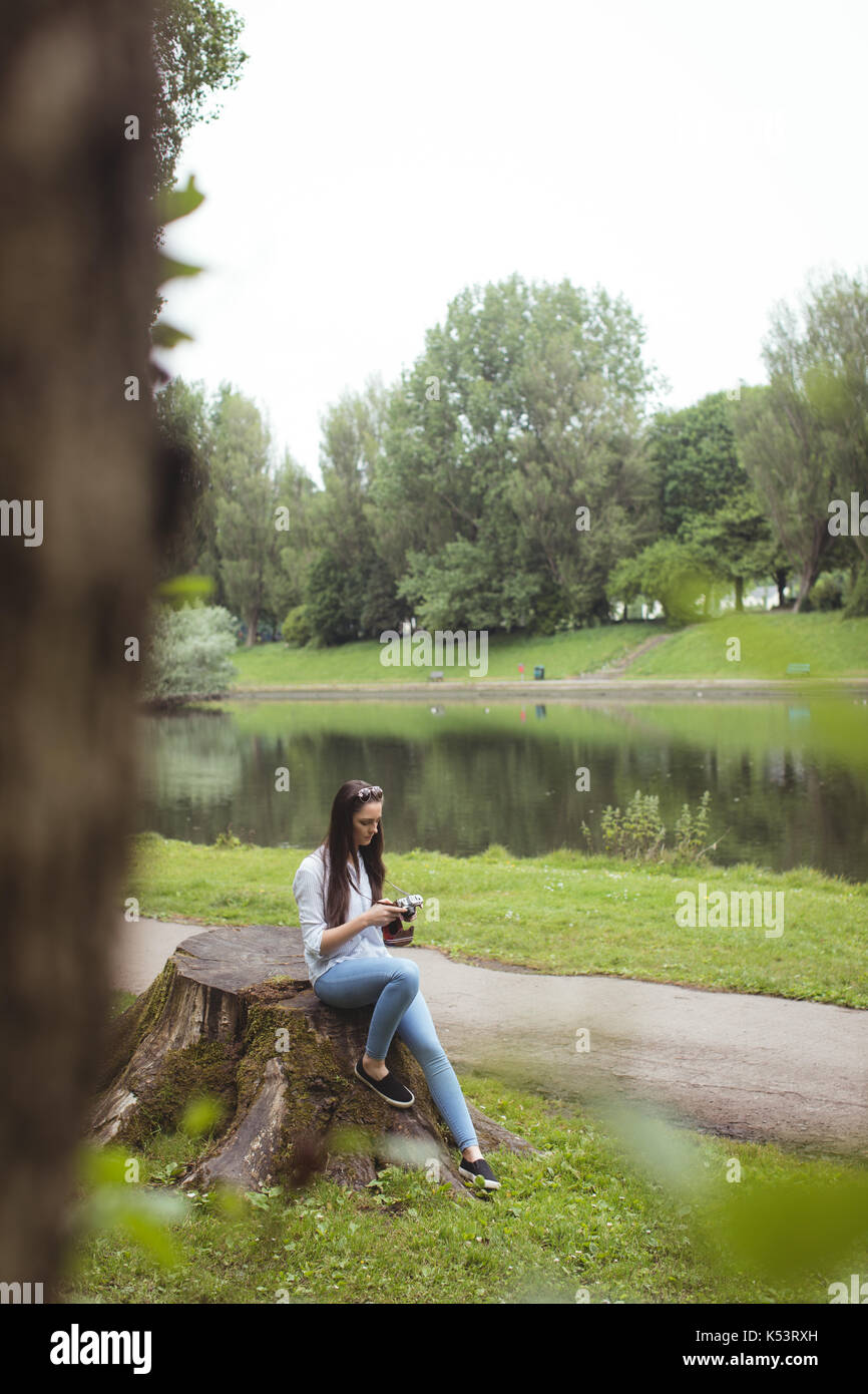 Woman looking clicked photos on vintage camera at forest Stock Photo ...