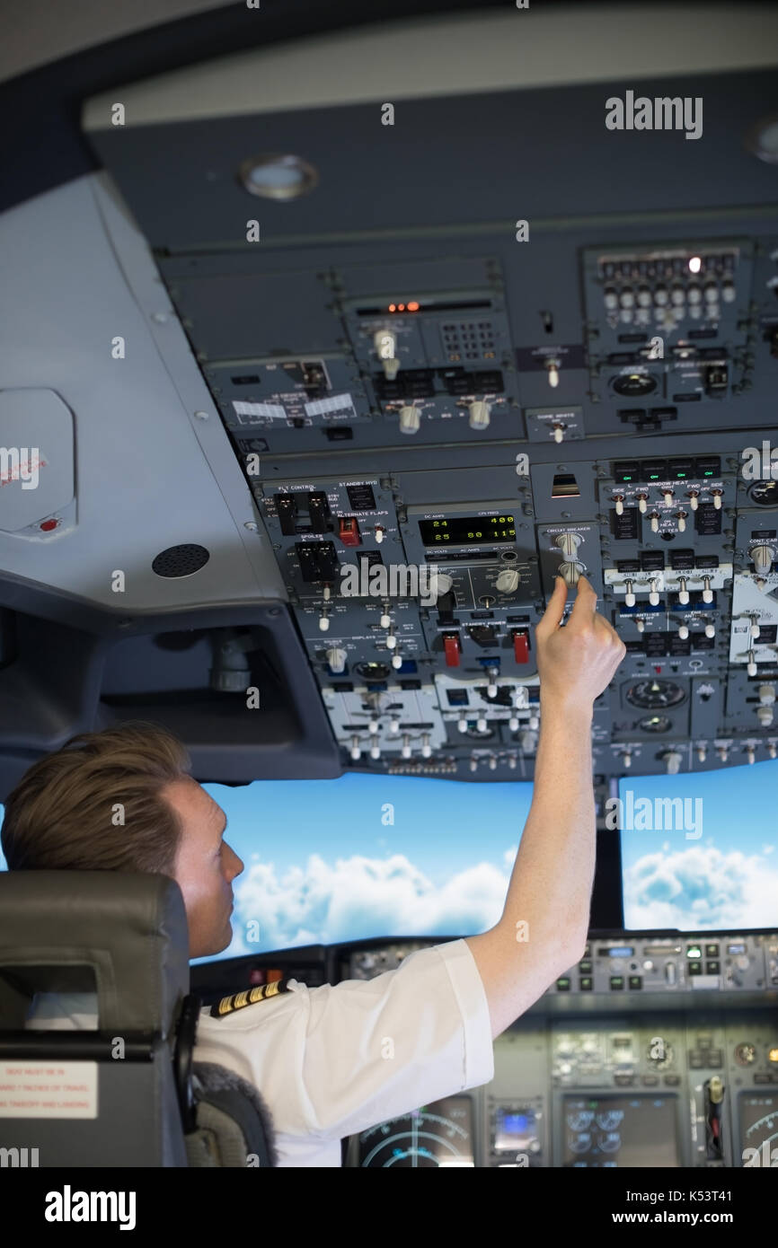 Rear view of male pilot switching controls in air vehicle cockpit Stock ...