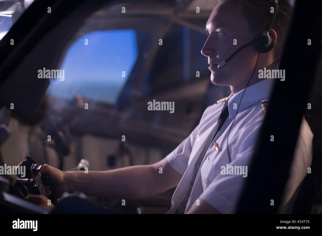 Side view of young male pilot flying airplane Stock Photo - Alamy