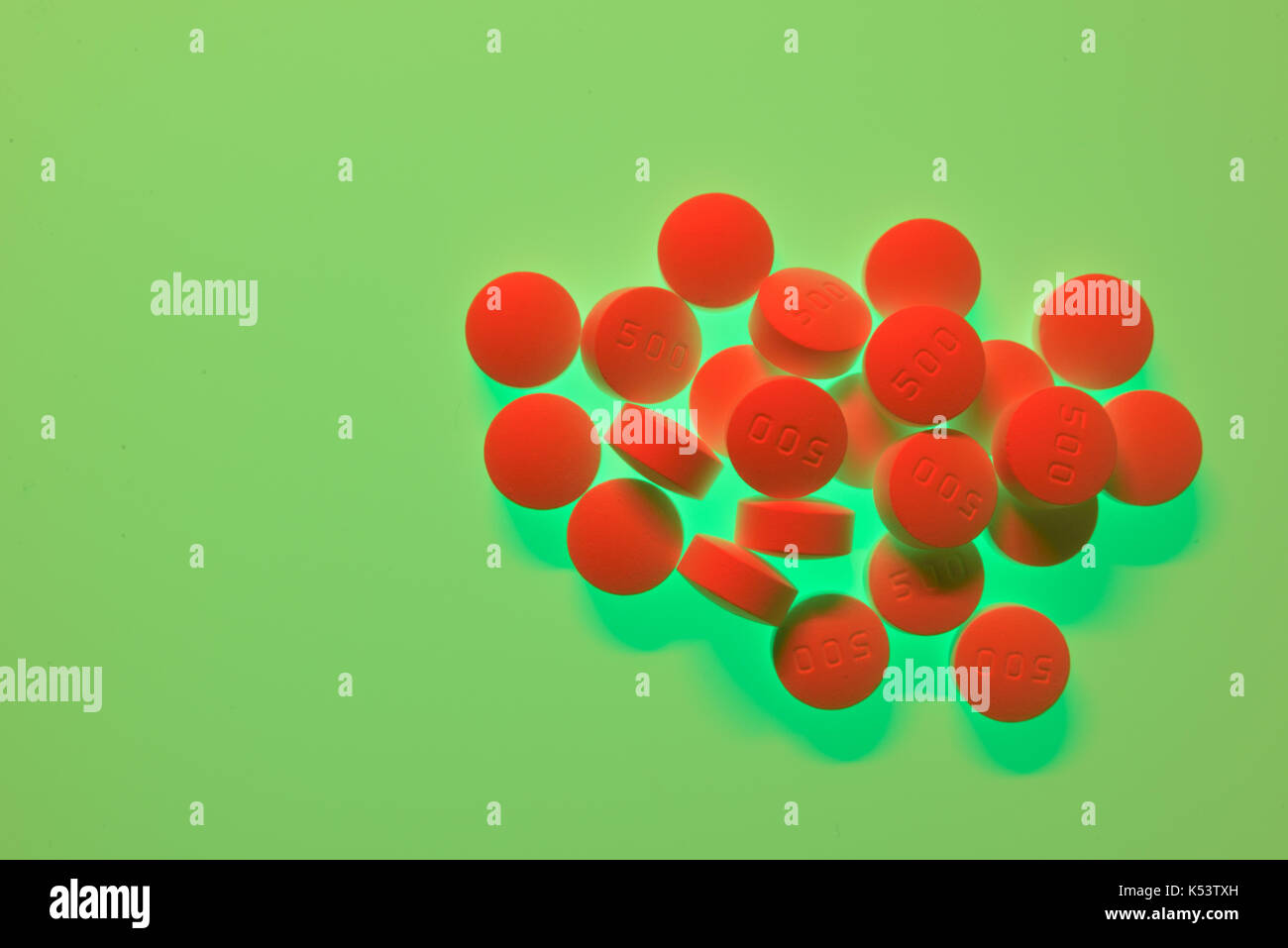 Red Medication tablets, on green surface Stock Photo - Alamy