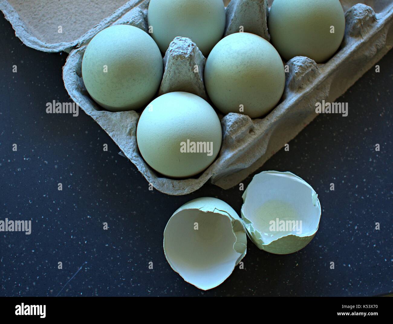 Green eggs in egg box and one cracked egg shell Stock Photo - Alamy