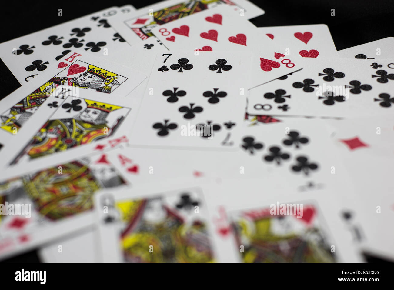 Playing cards splattered over a table Stock Photo - Alamy