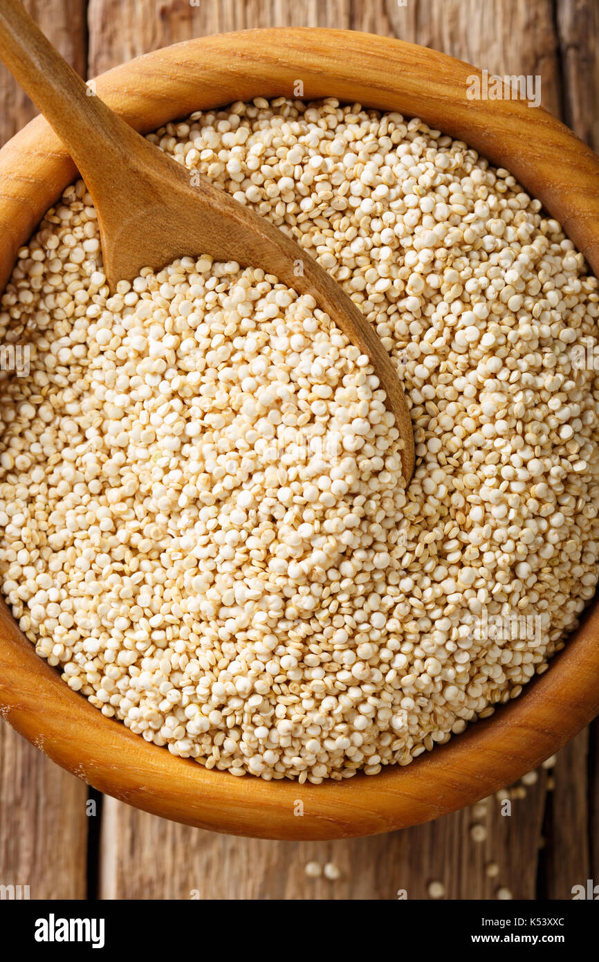 Traditional raw quinoa close up in a wooden bowl on the table. top view ...
