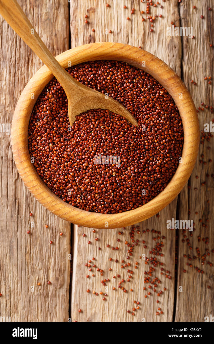 Organic raw red quinoa close-up in a wooden bowl on the table. top view ...