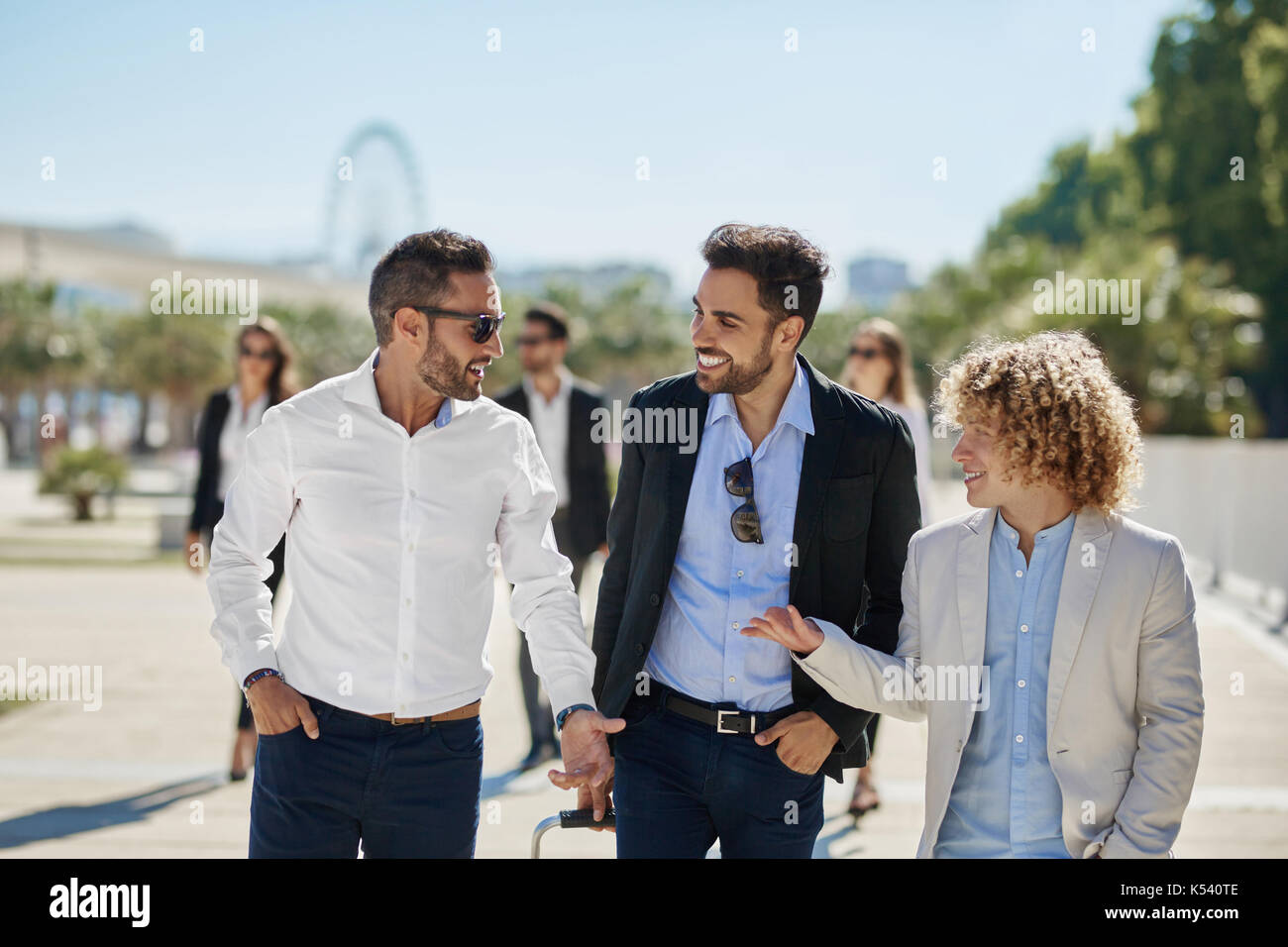 Portrait of three happy businessmen having conversation outside Stock ...