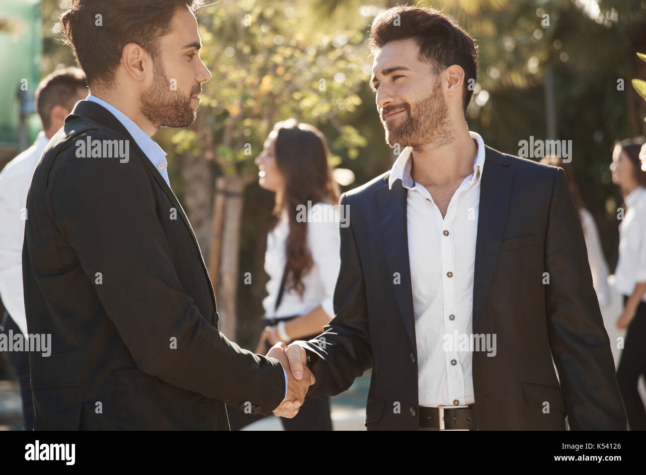 Portrait of two businessmen shaking hands outside Stock Photo - Alamy