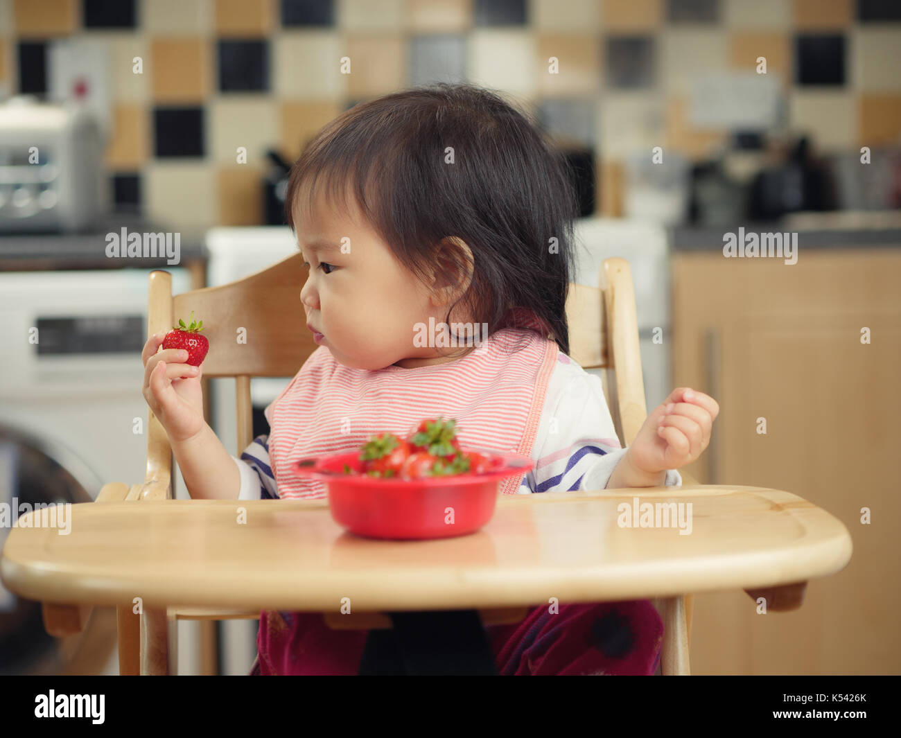 baby girl eating food at home Stock Photo - Alamy