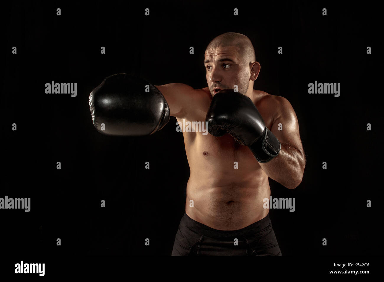 The young man kickboxing on black Stock Photo - Alamy