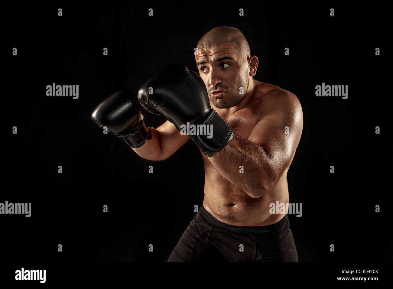 The young man kickboxing on black Stock Photo - Alamy