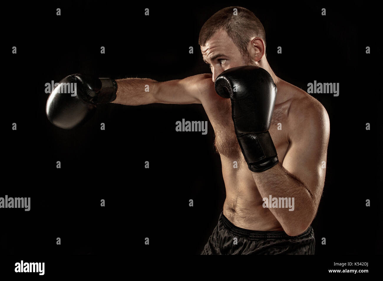 The young man kickboxing on black Stock Photo - Alamy