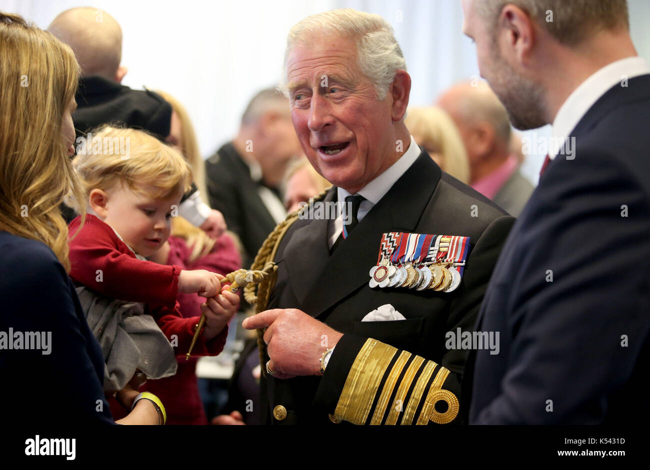 18 month old Imogen Holm pulls the braid on the uniform of the Prince ...