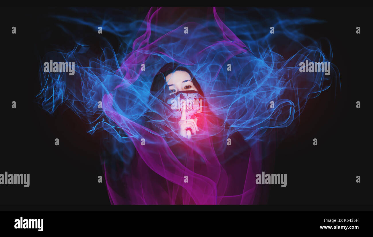 Girl wearing a skull mask with the finger on mouth asking for silence ...