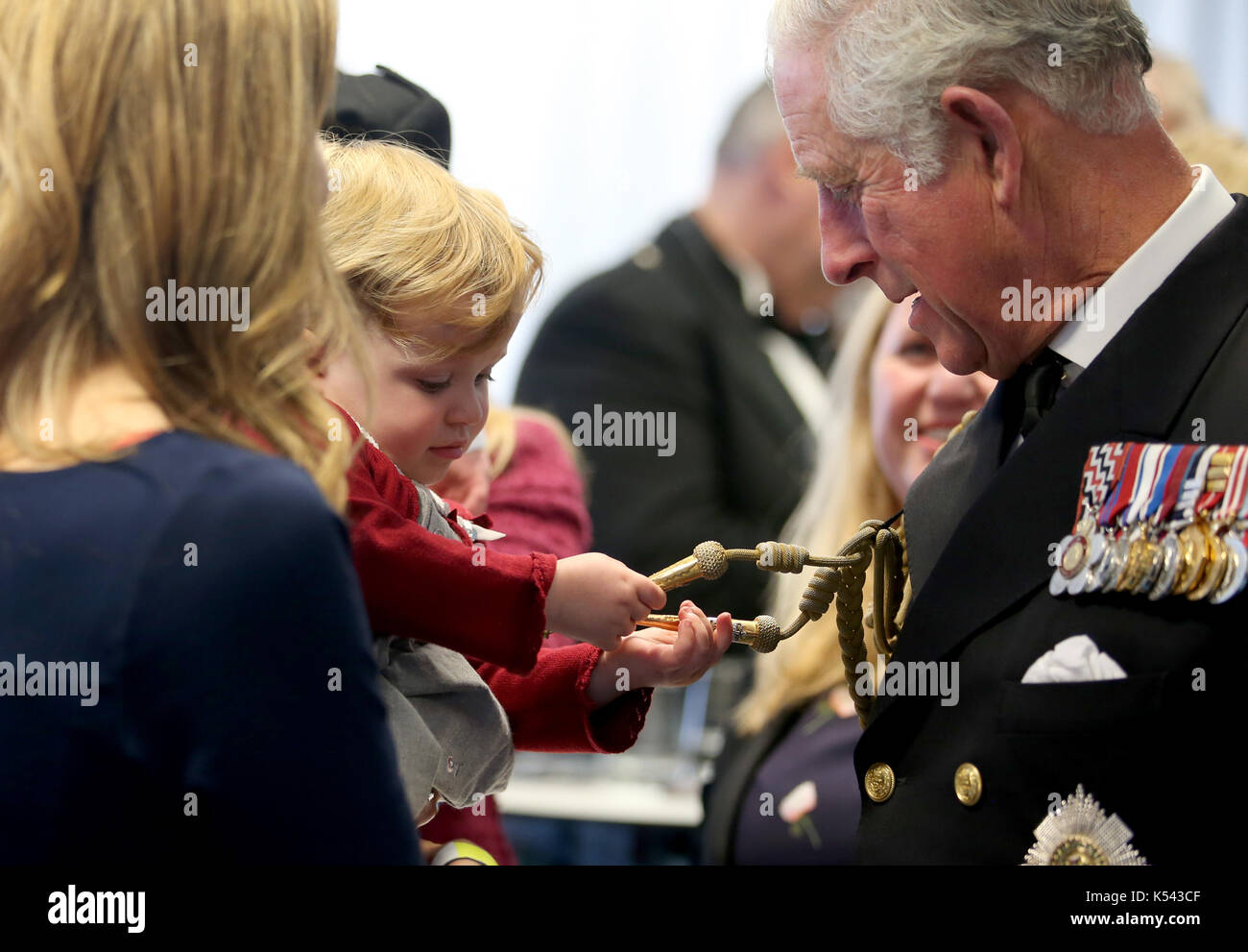 18 month old Imogen Holm pulls the braid on the uniform of the Prince ...