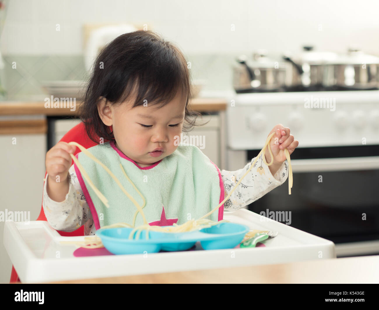 baby girl eating at home Stock Photo - Alamy