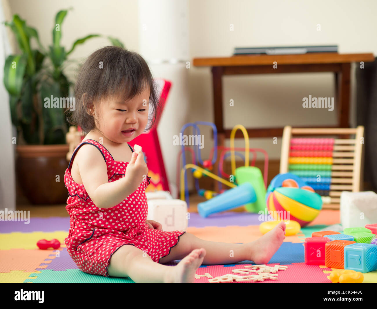 baby girl playing alphabet blocks at home Stock Photo - Alamy