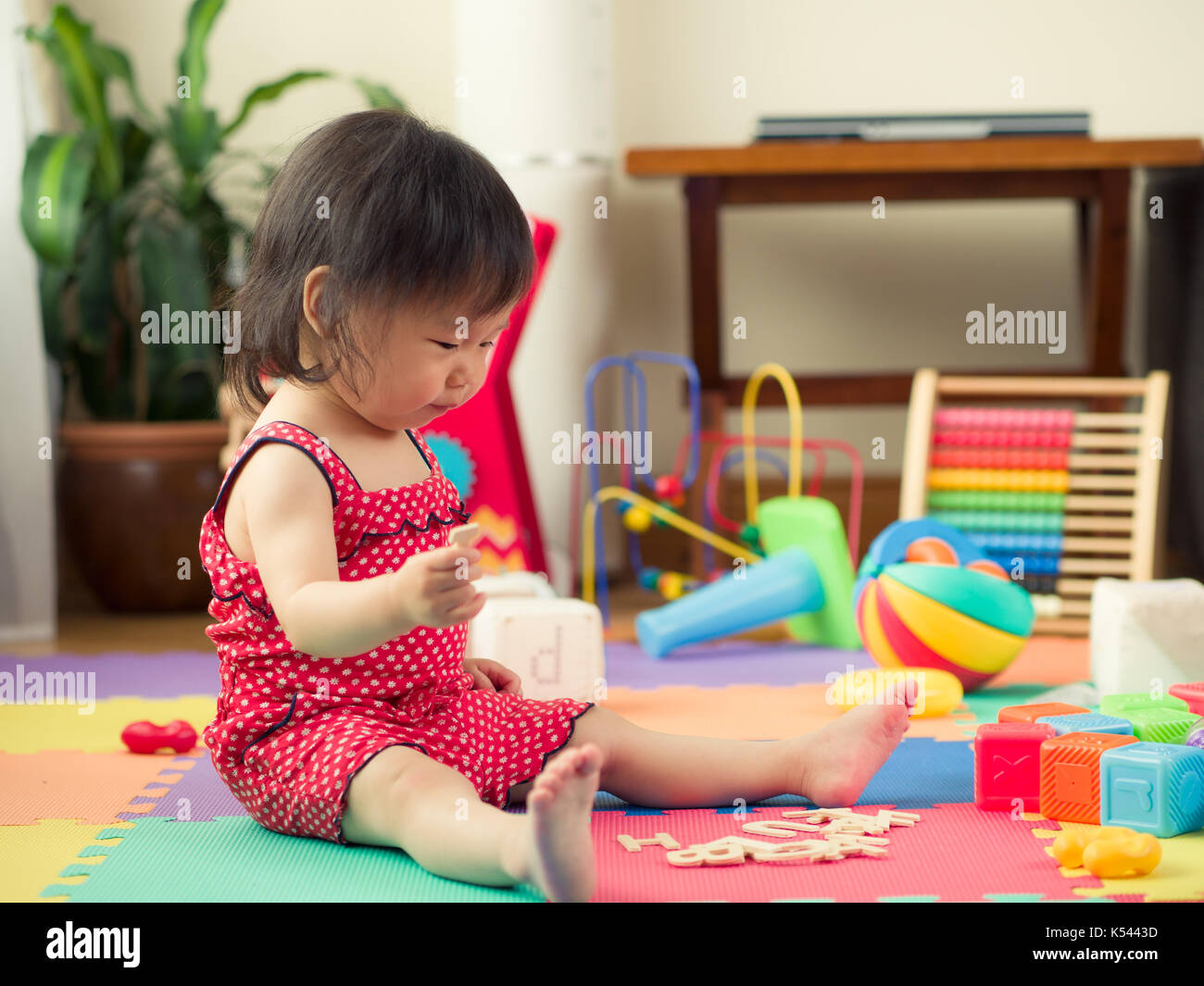 baby girl playing alphabet blocks at home Stock Photo - Alamy
