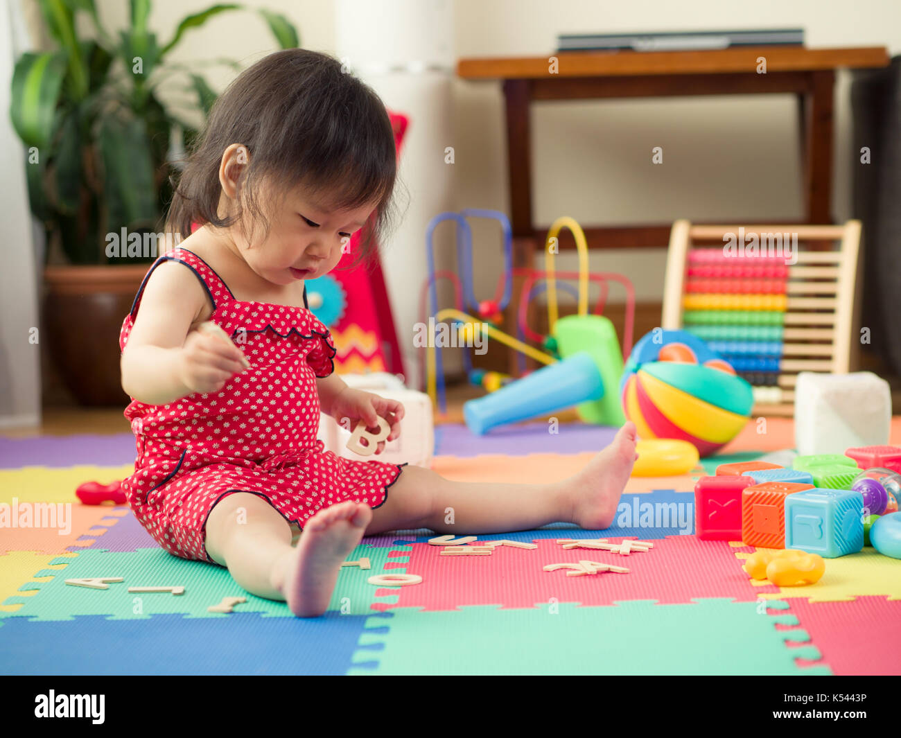 baby girl playing alphabet blocks at home Stock Photo - Alamy