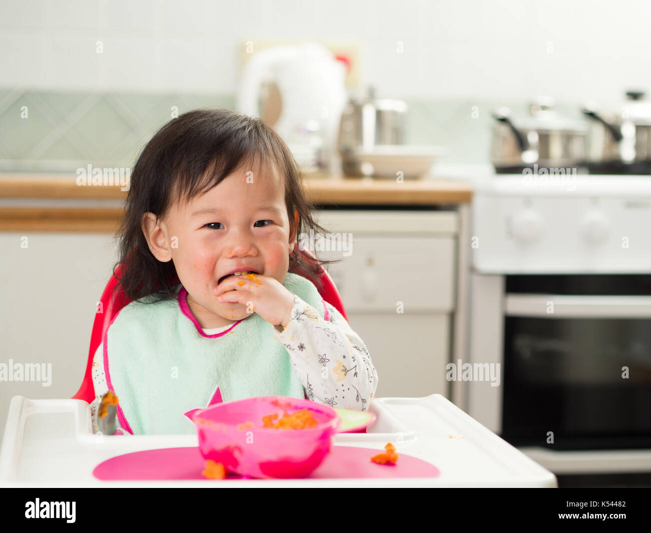 baby girl eating at home Stock Photo - Alamy