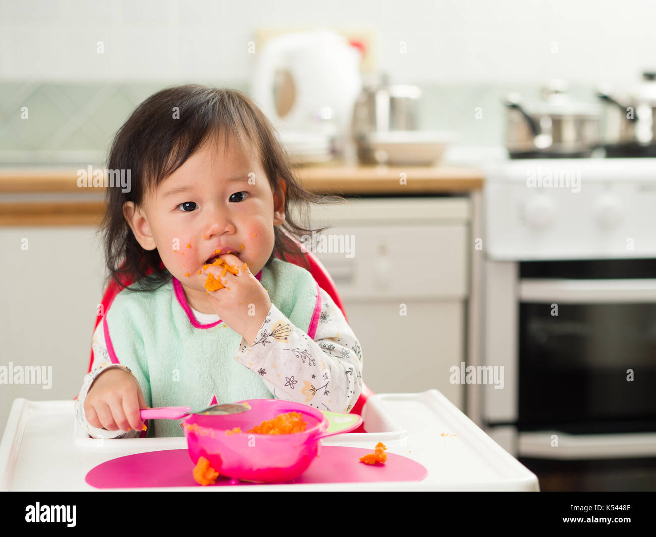 baby girl eating at home Stock Photo - Alamy
