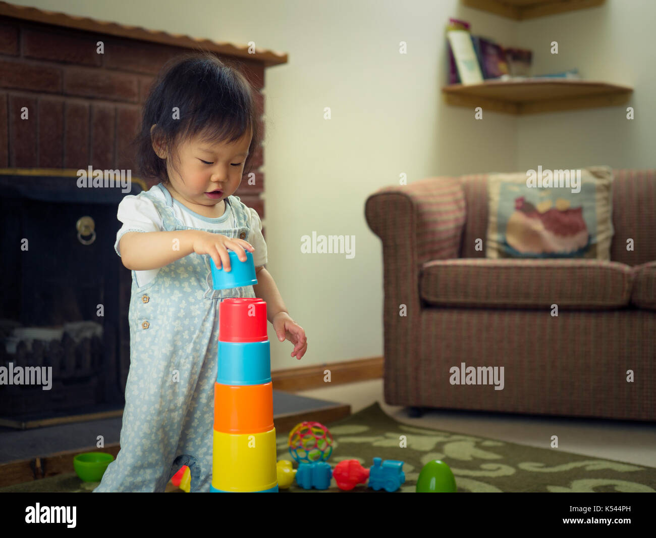 baby girl playing stacking cups at home Stock Photo - Alamy