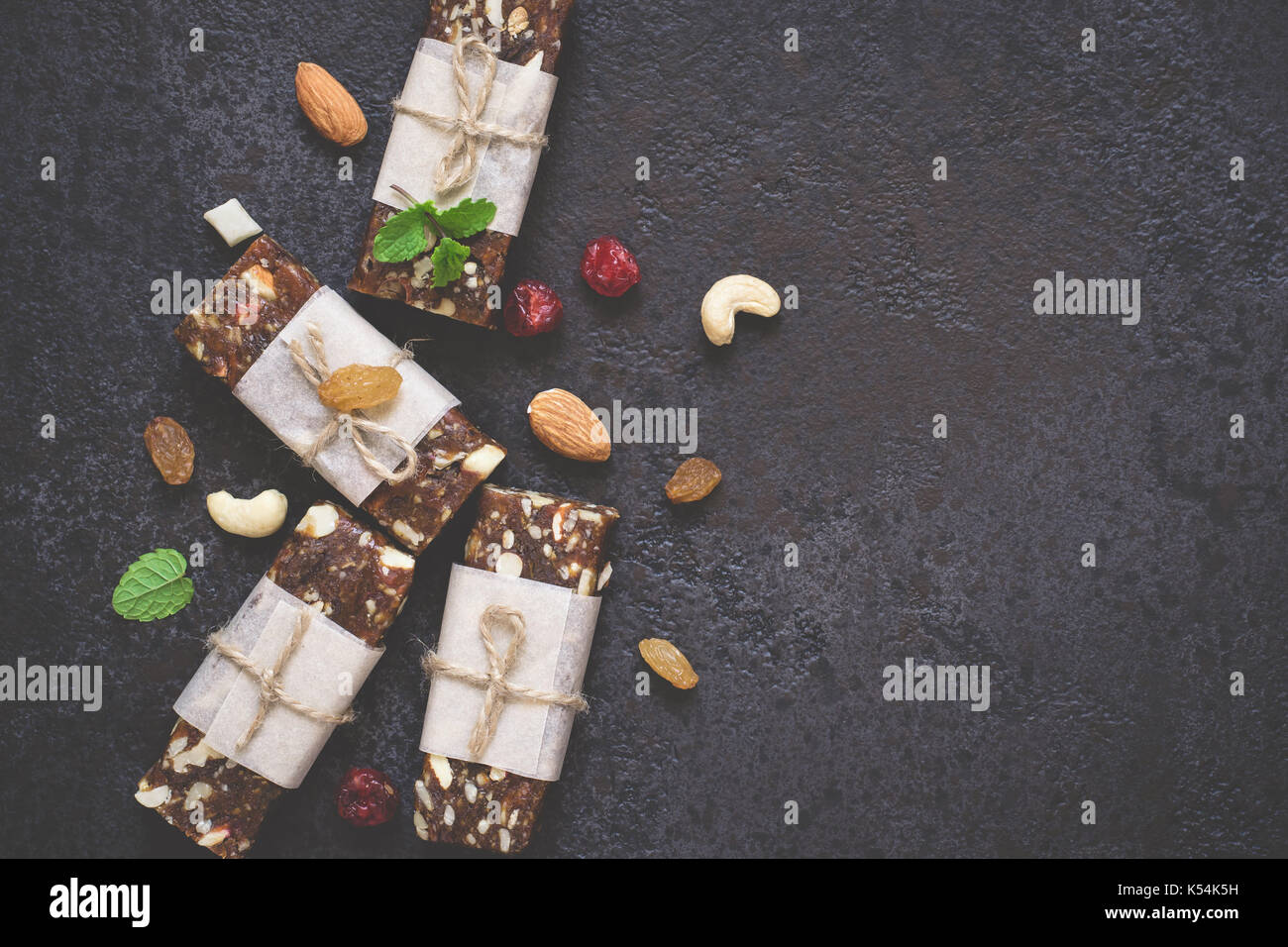 Healthy snack bars of dried fruits and nuts on black concrete ...