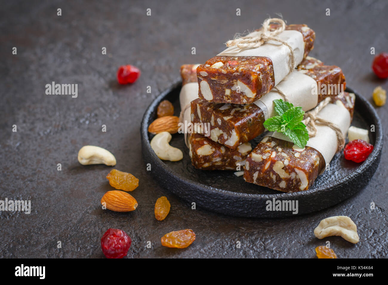 Healthy snack bars of dried fruits and nuts on black concrete ...