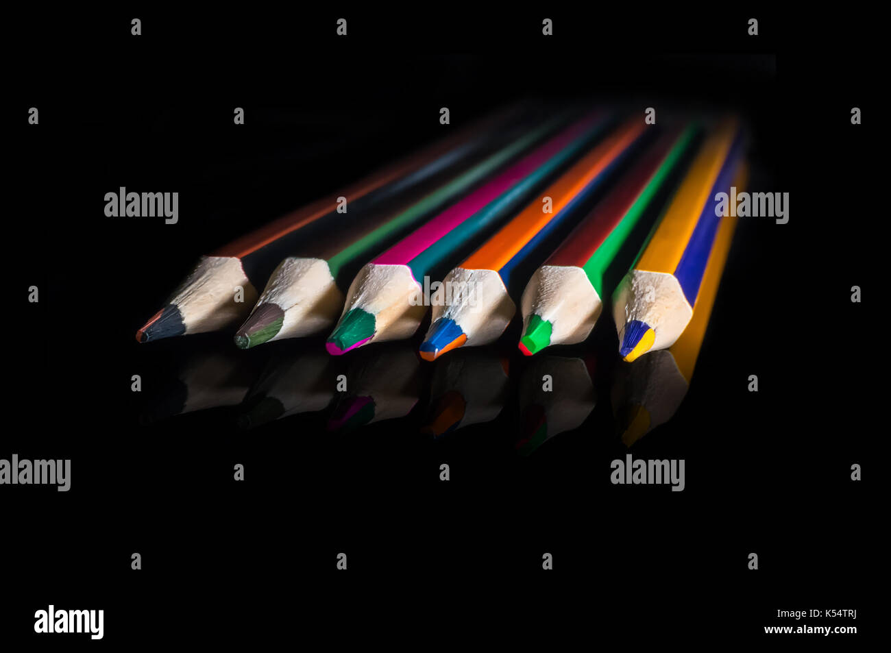 Colored pencils on black background reflected in mirror. Pencils with ...