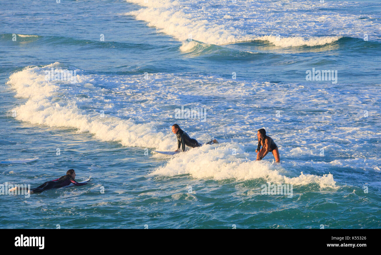 Teenage girls surfing at sunrise at Redgate Beach in Margaret River ...