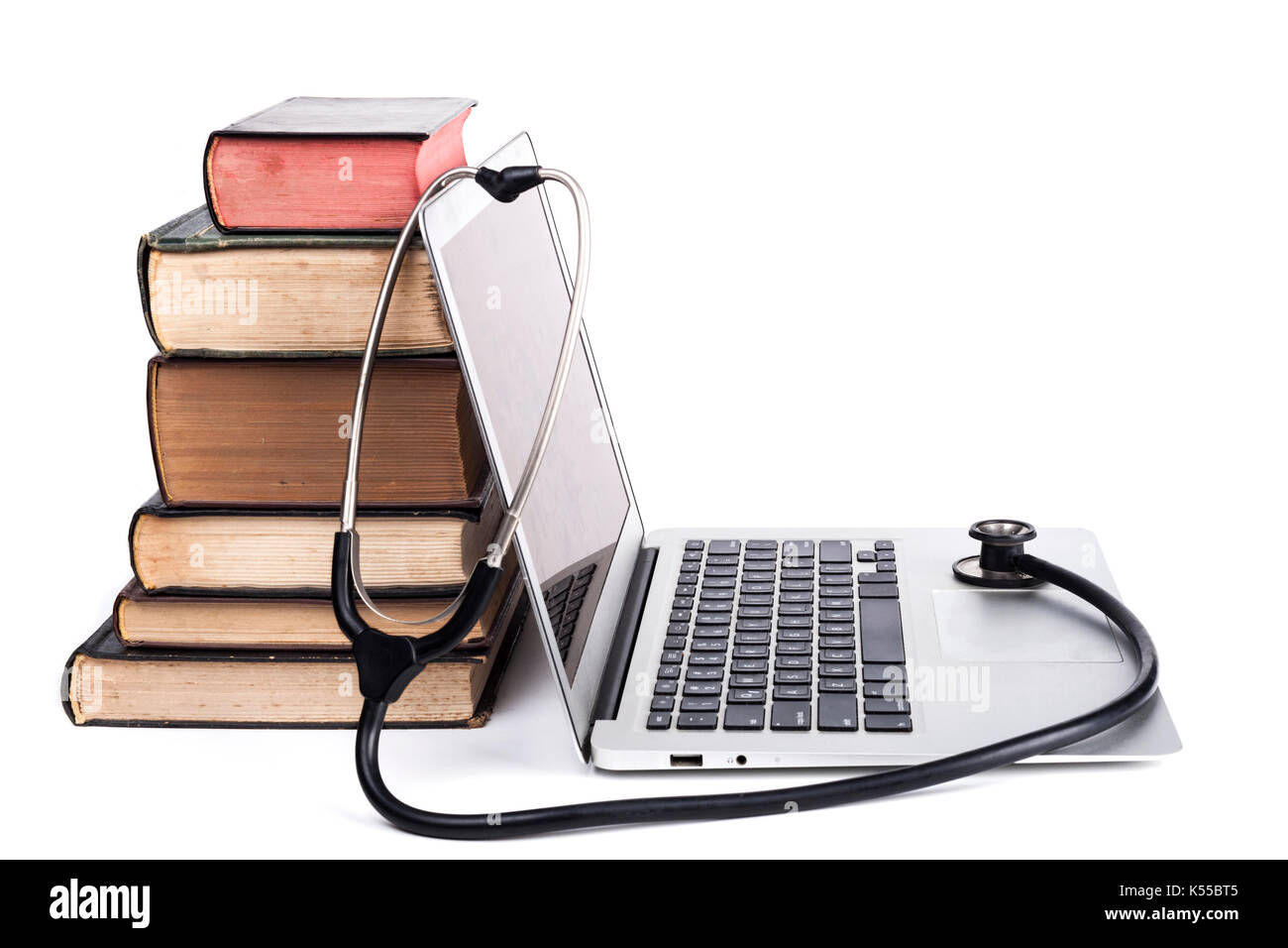 Silver laptop with black stethoscope and old books pile isolated on ...