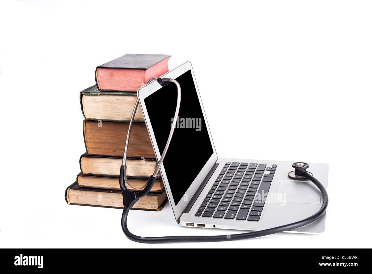 Silver laptop with black stethoscope and old books pile isolated on ...
