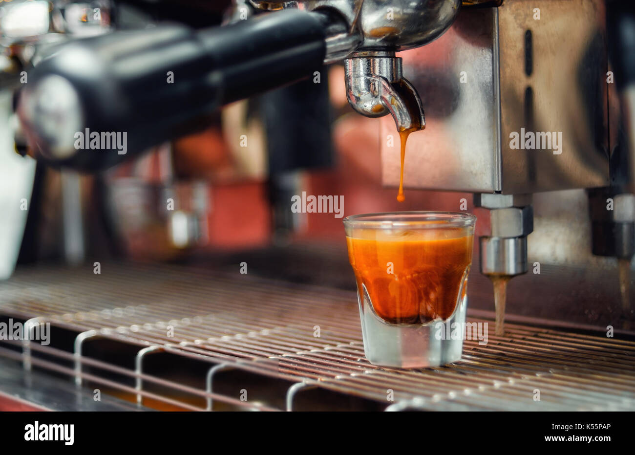 glass of fresh espresso with a falling drop in it. The process of ...