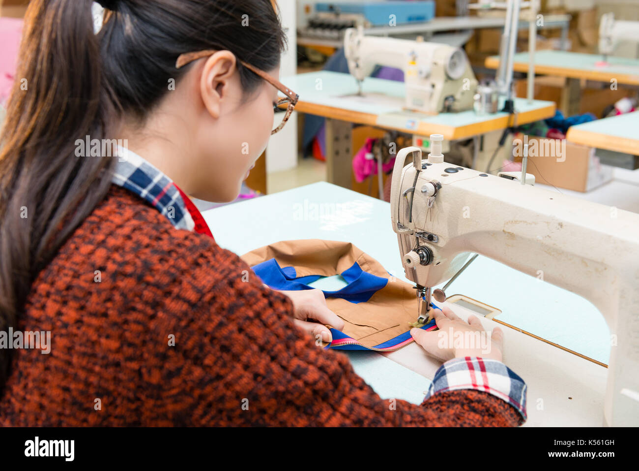 closeup photo of attractive beauty female sewing employee using tailor ...