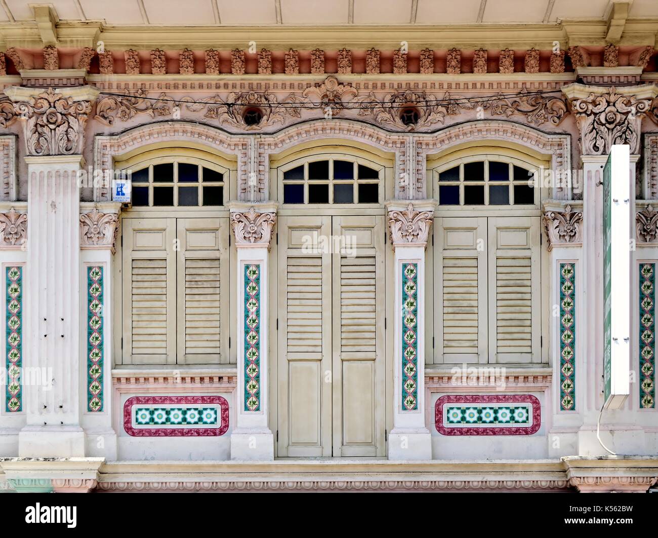 Traditional shop house exterior with white wooden louvered shutters and ...