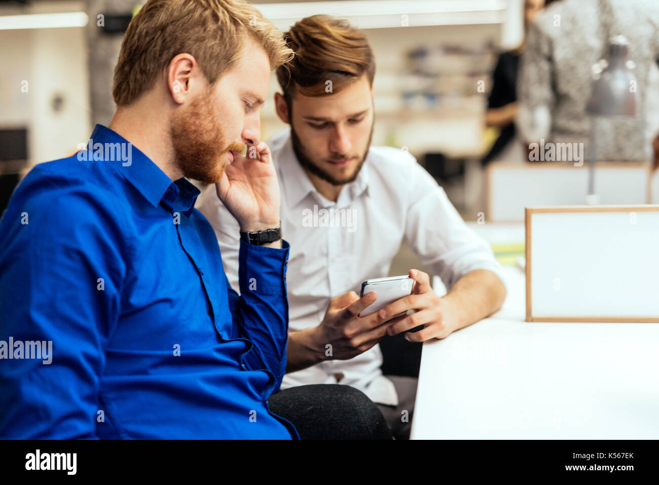 Handsome businessmen using phones in office Stock Photo - Alamy