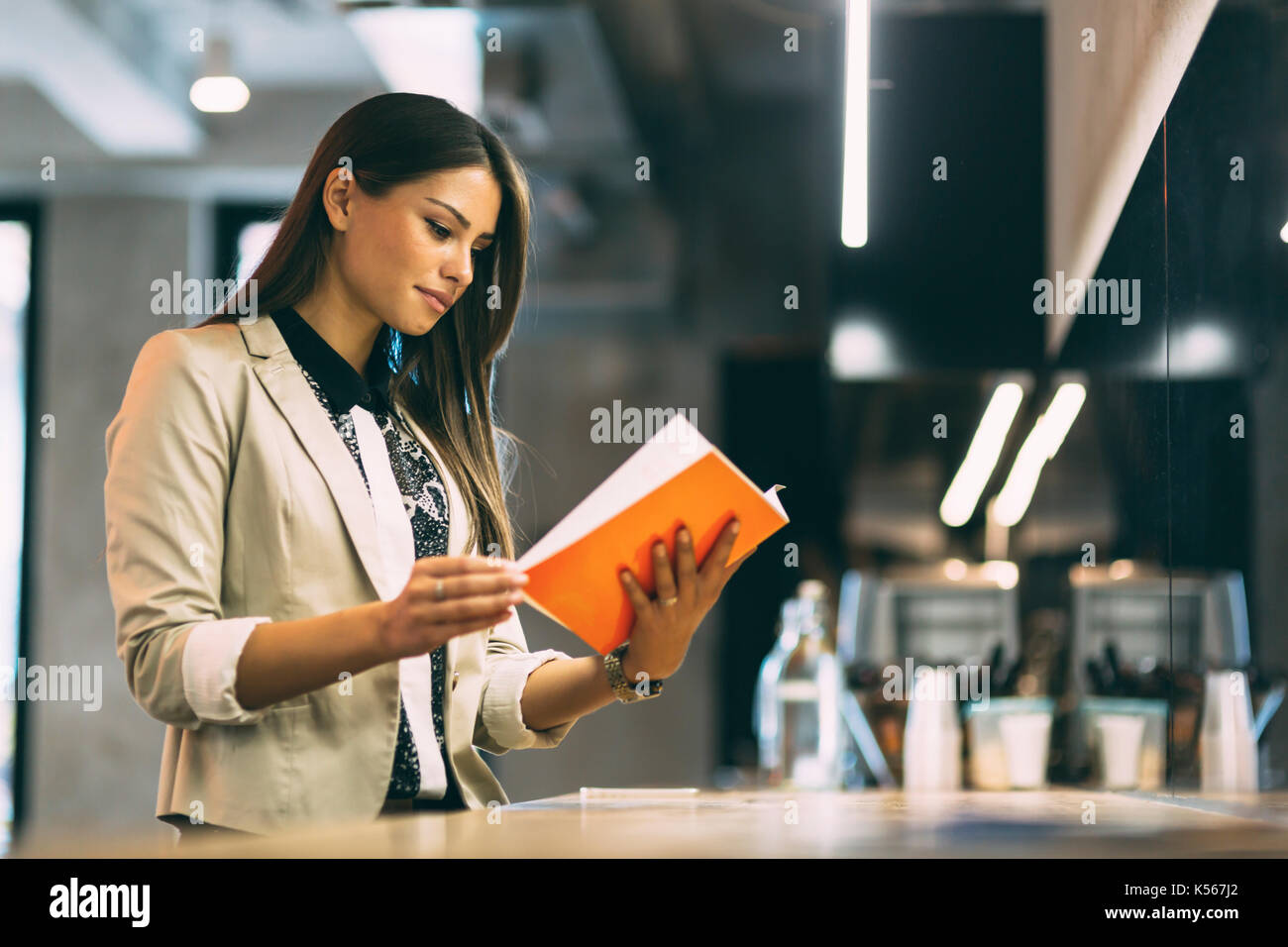 Beautiful woman reading the menu on a counter Stock Photo - Alamy